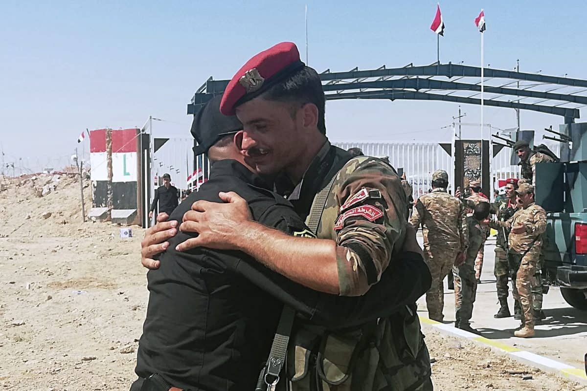Soldiers embrace as Iraq and Syria re-open key border crossing
